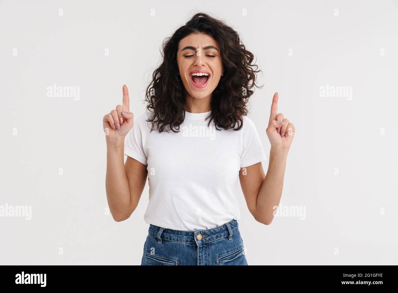 Joyful beautiful brunette girl screaming and pointing fingers upward ...