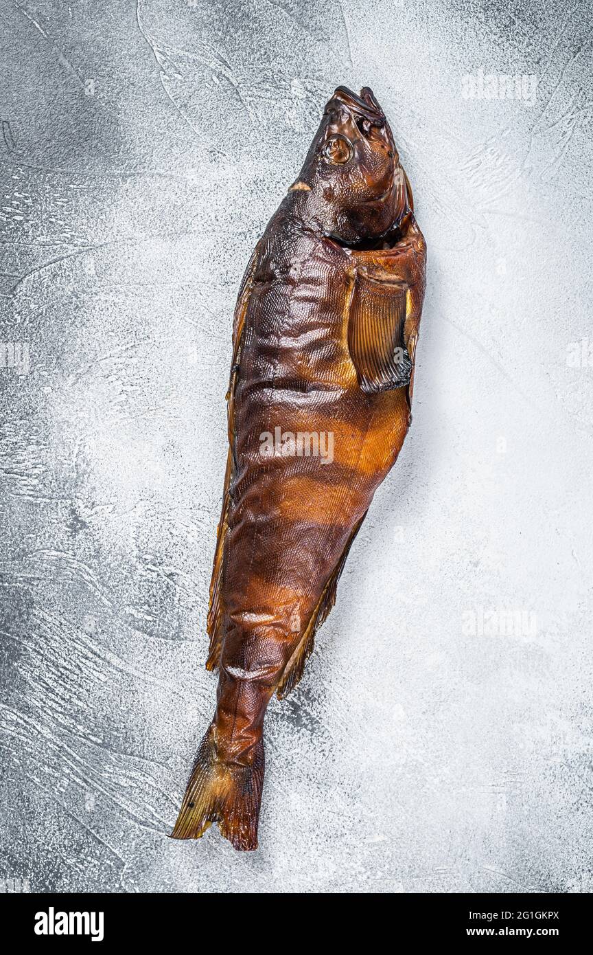 Hot smoked whole fish on kitchen table. White background. Top view ...