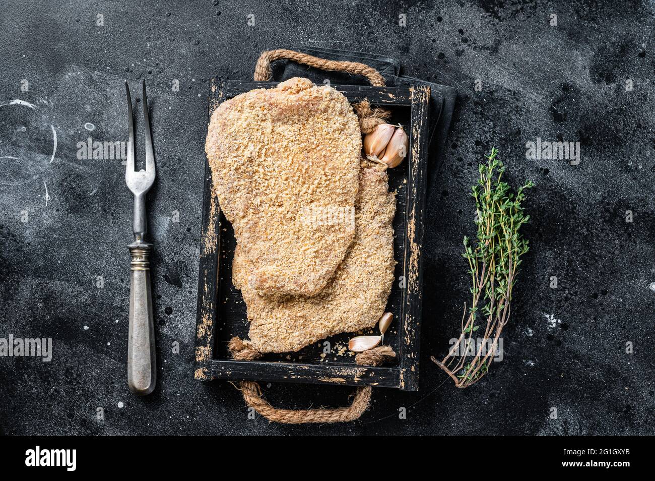 Homemade German Wiener Raw schnitzel in a wooden tray. Black background ...