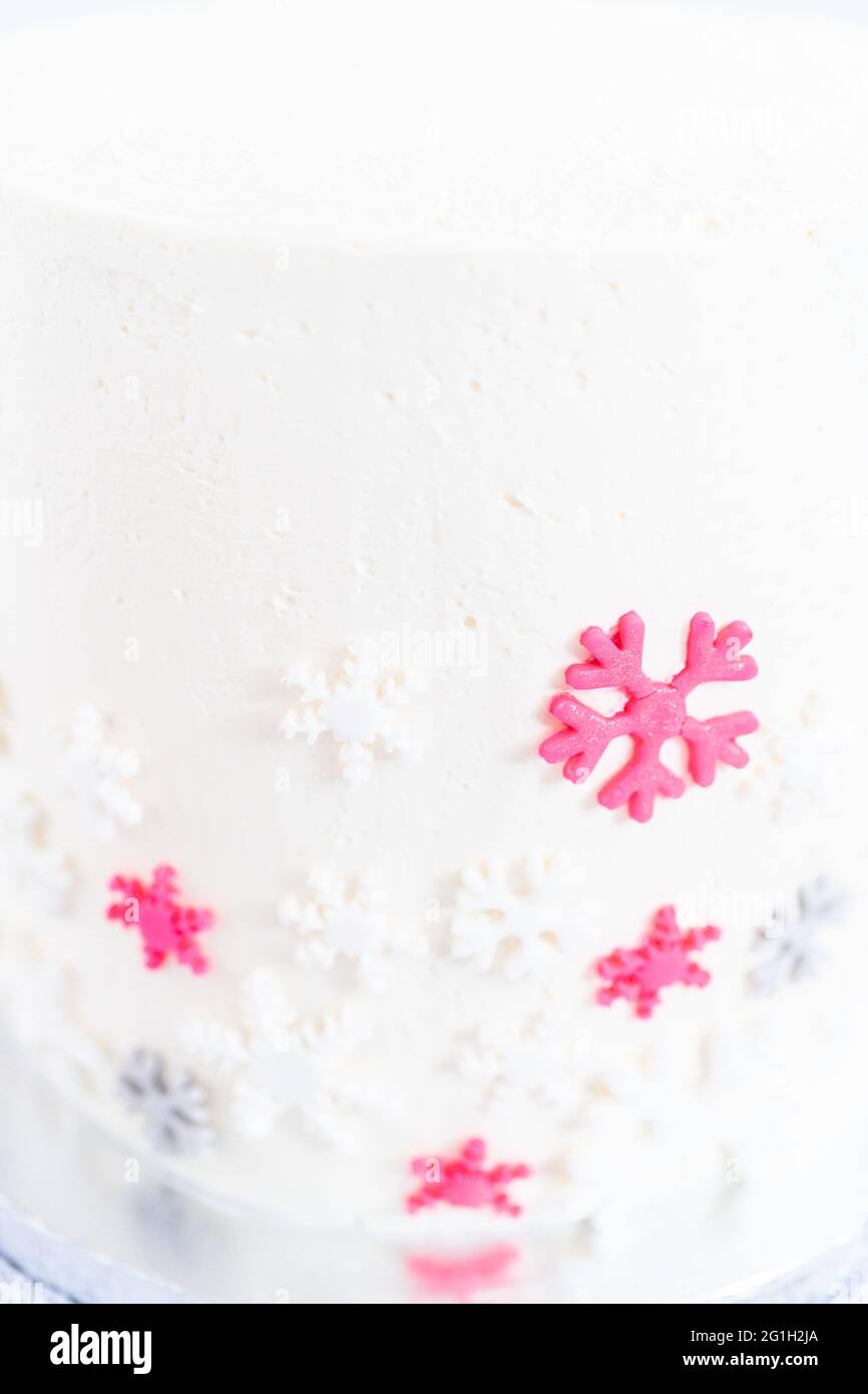 Frosting a tall round cake with white Italian buttercream icing and ...