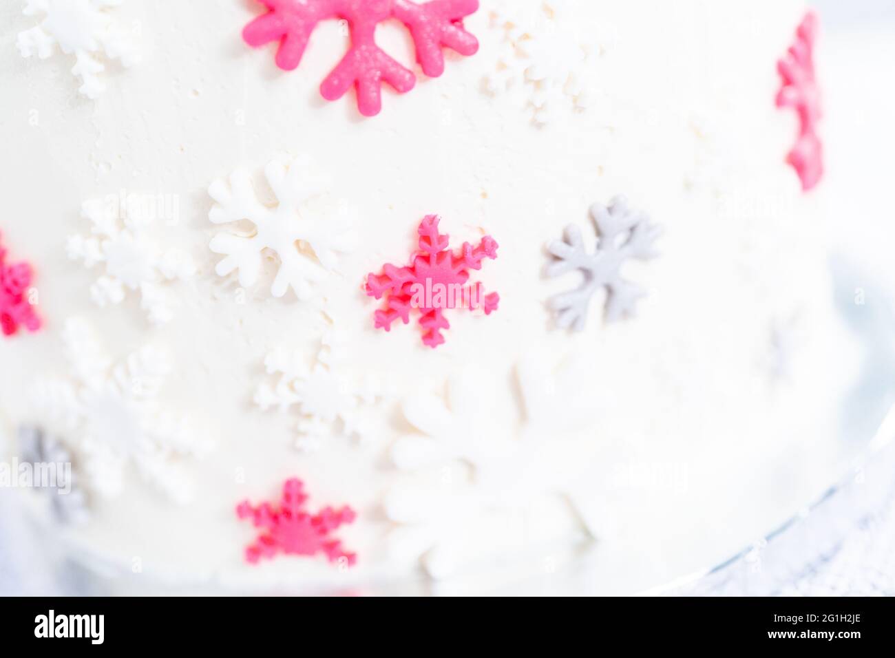 Frosting a tall round cake with white Italian buttercream icing and ...