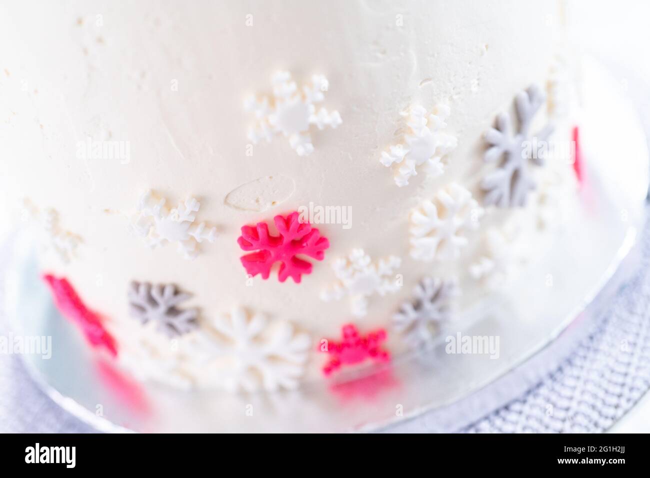 Frosting a tall round cake with white Italian buttercream icing and ...