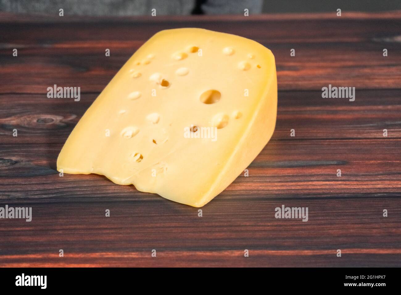 Large wedge of semi soft part-skim swiss cheese on a dark wooden ...