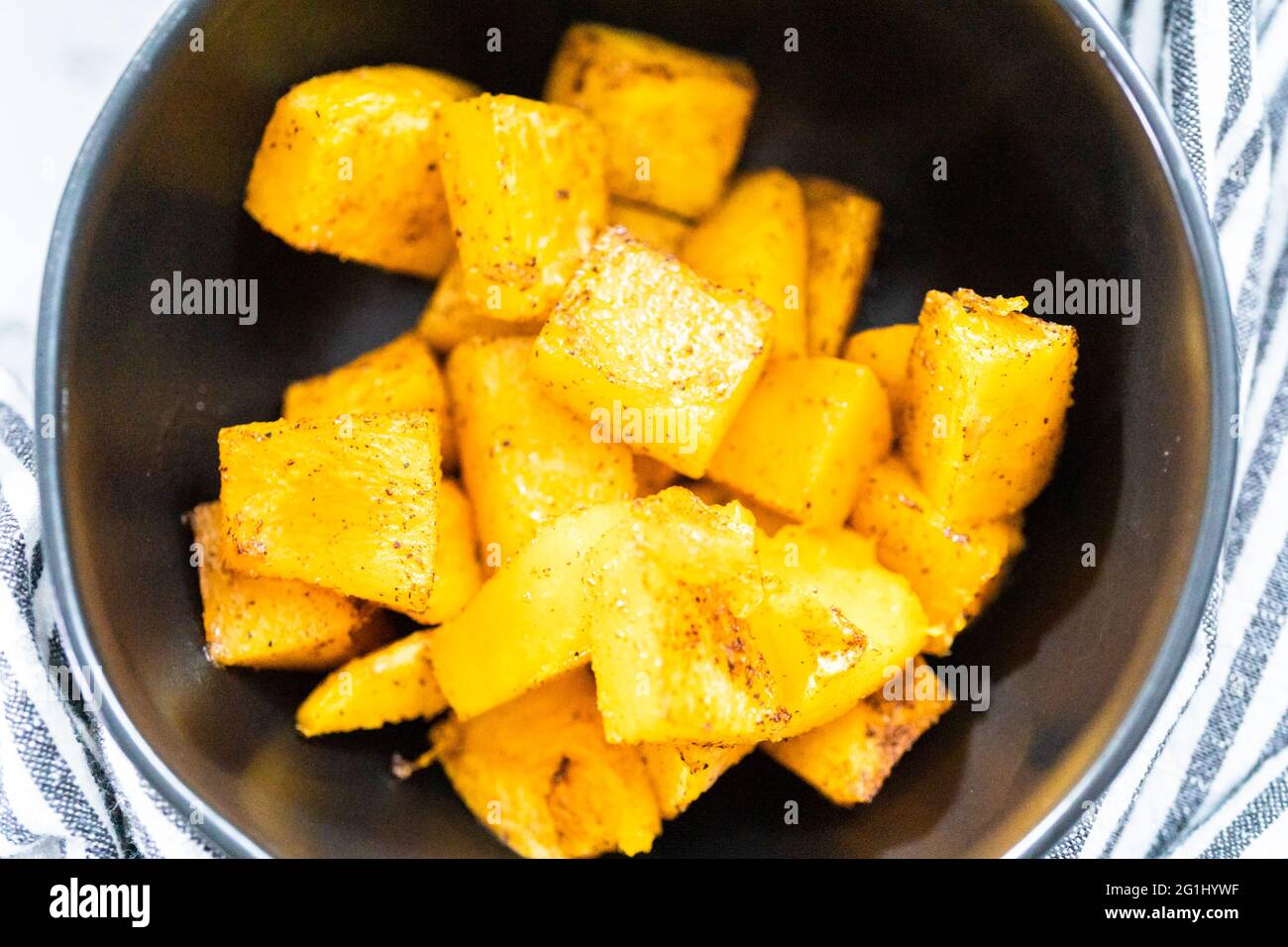 Roasting butternut squash with salt and pepper in olive oil Stock Photo ...
