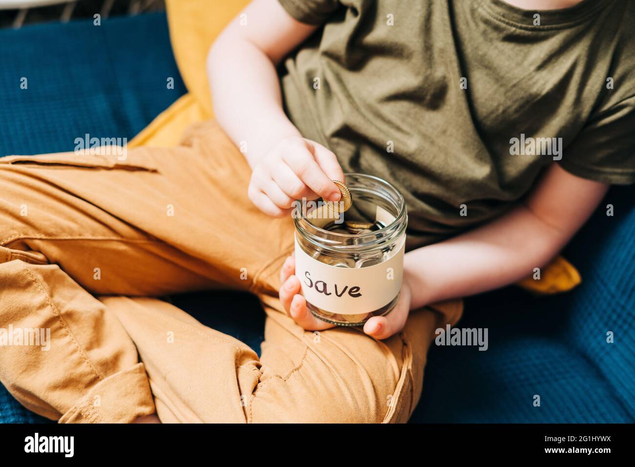 Close up of Little child kid boy hands grabbing and putting stack coins ...