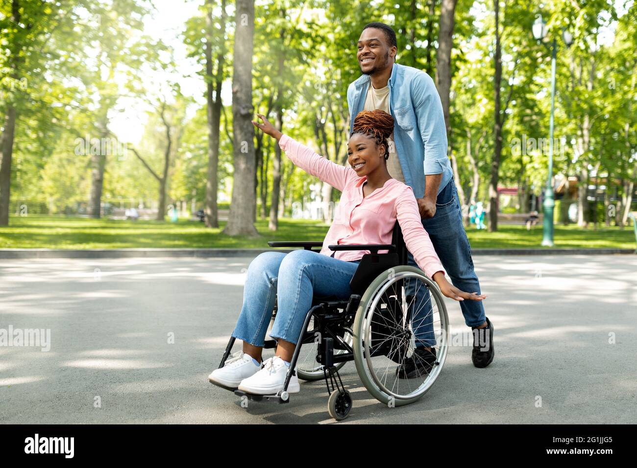 Full length of joyful black guy and his disabled girlfriend in ...