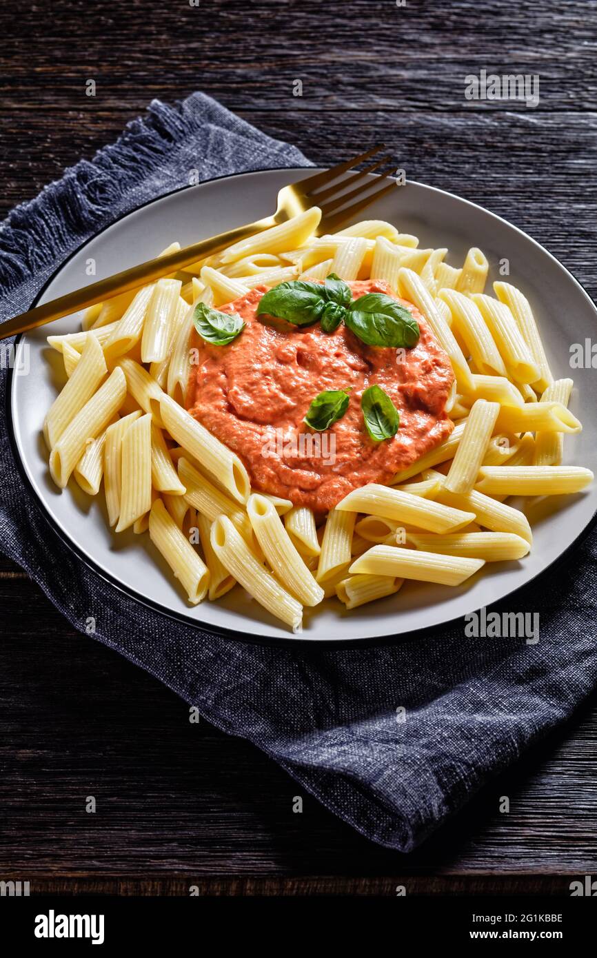 Parma Rosa Sauce with Penne on a plate on a dark wooden table Stock ...