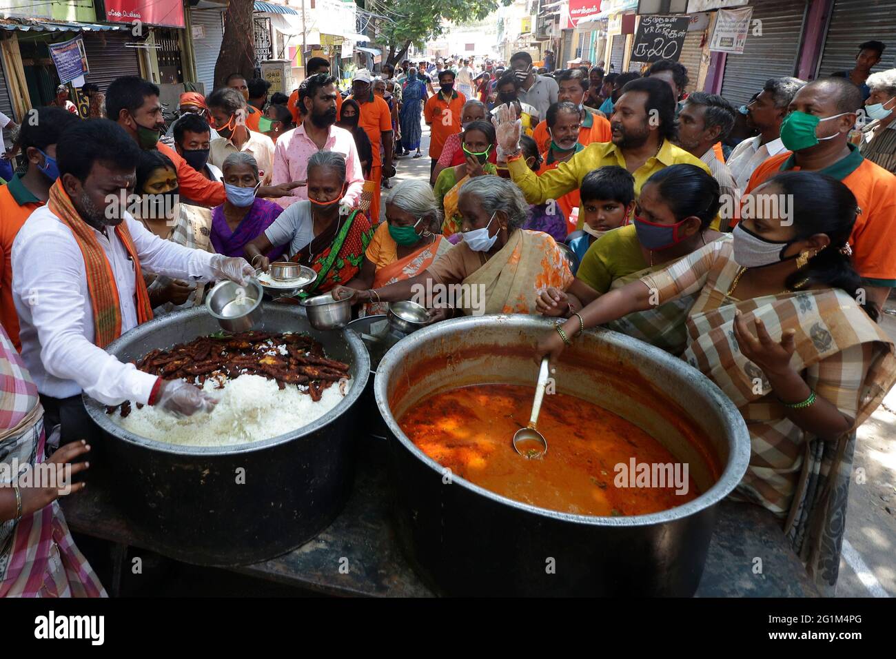 (6/6/2021) Local residents wait in a queue to get free food provided by ...