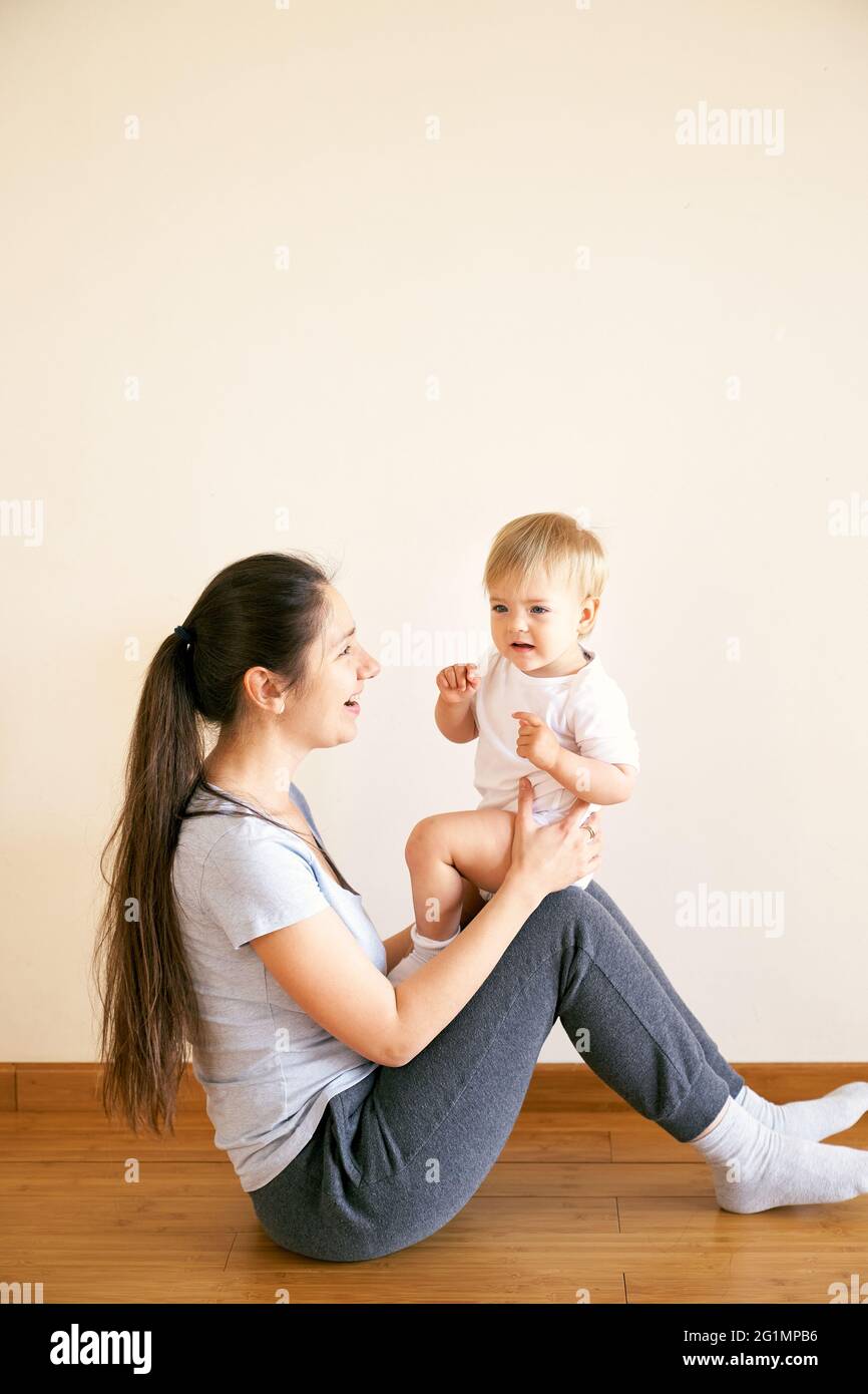 Small family with a child sits on the floor hi-res stock photography ...