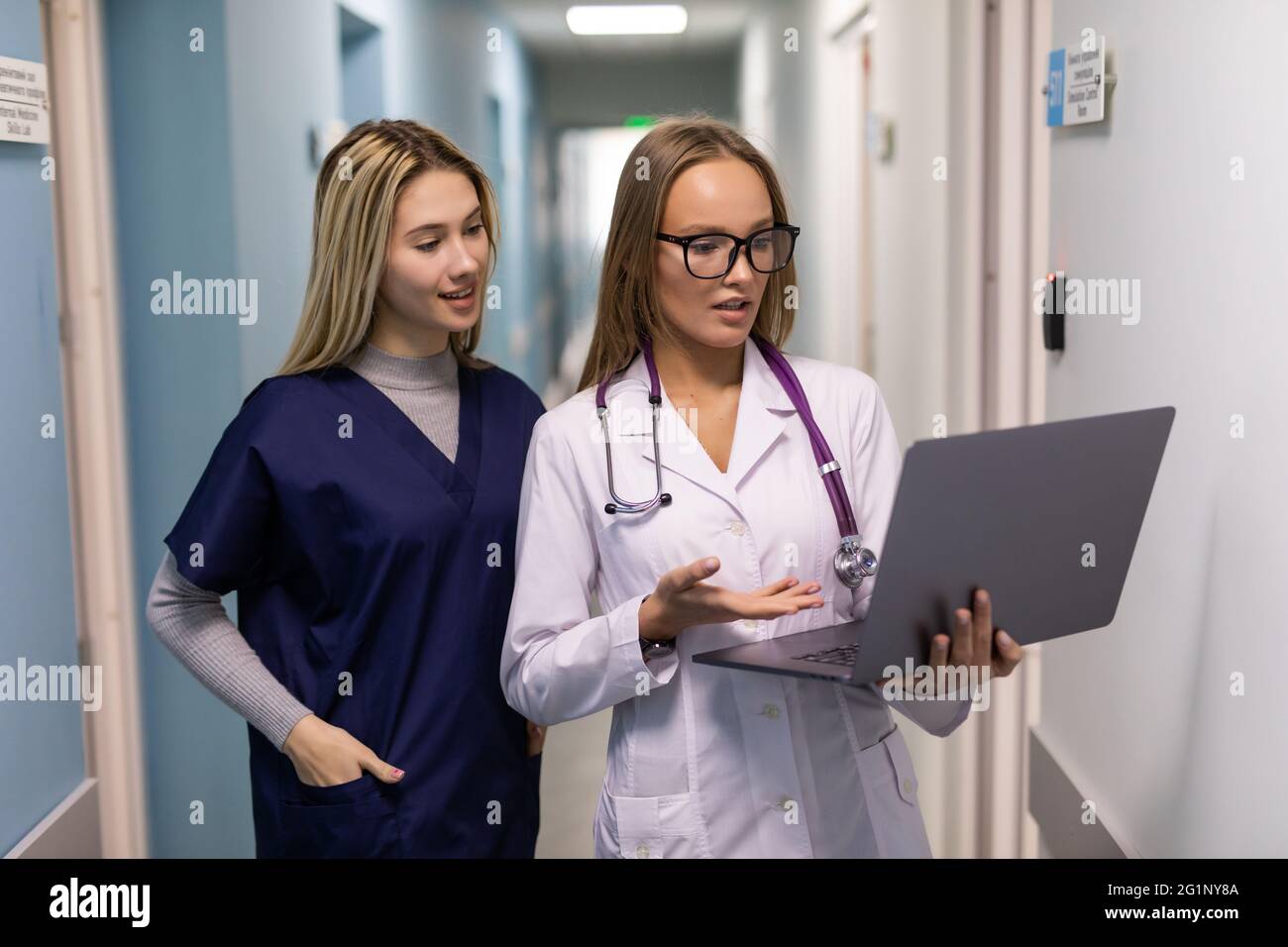 Two medical doctors using notebook computer to discuss patients healh ...