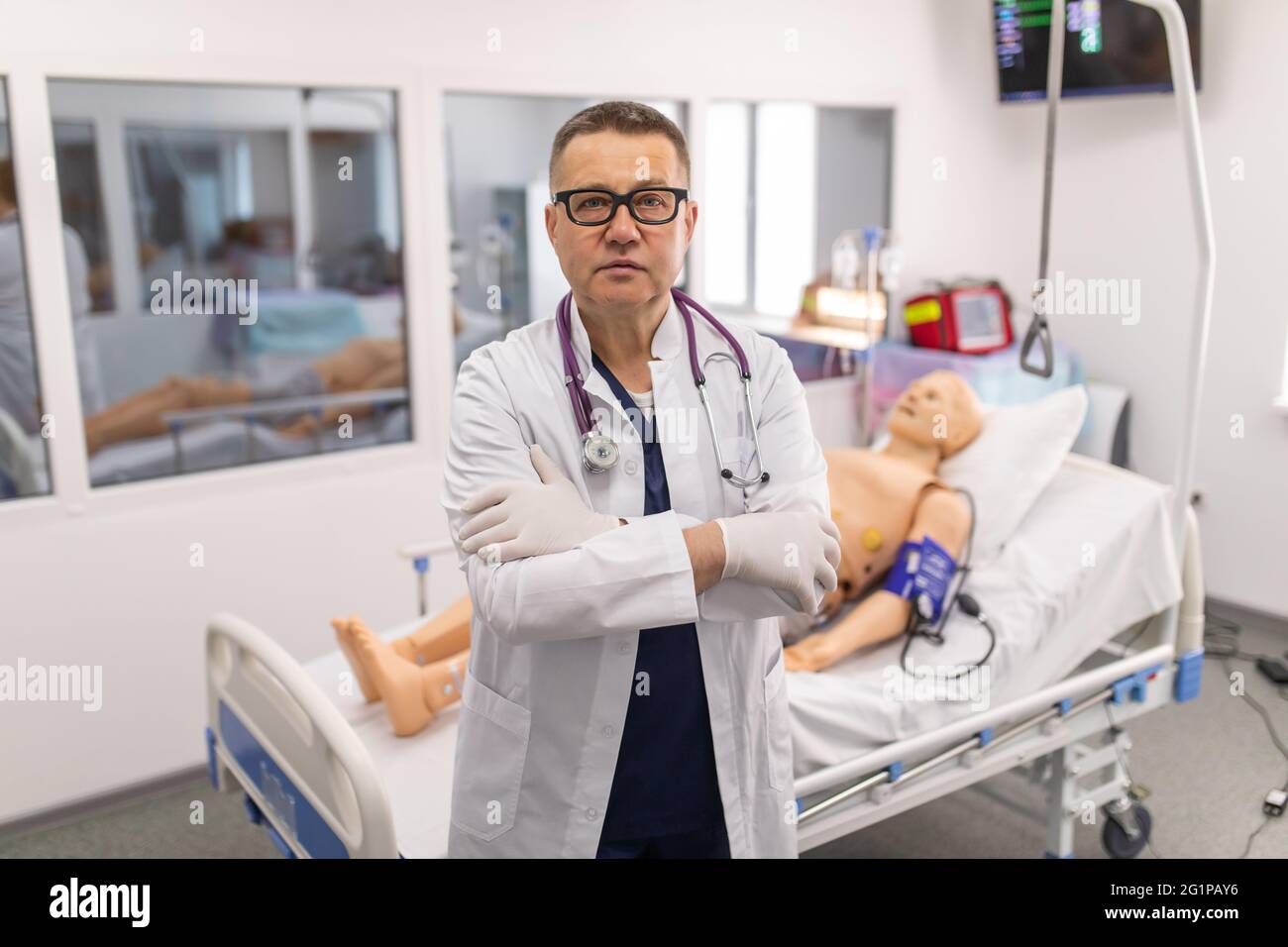 Doctor teacher in front of simulation room in hospital. Medical teach ...