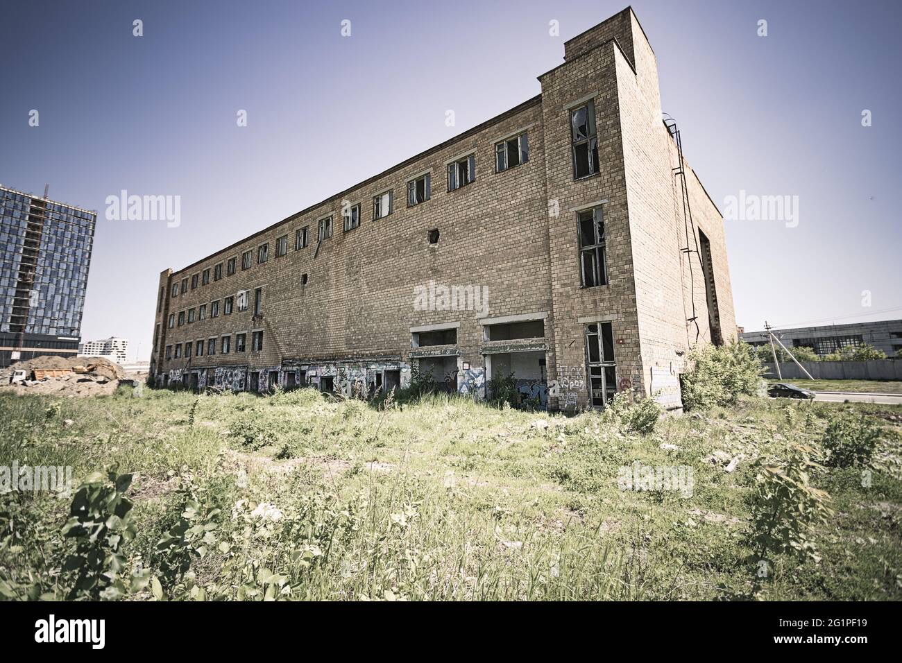 Abandoned multi-story red brick factory building with broken glass ...
