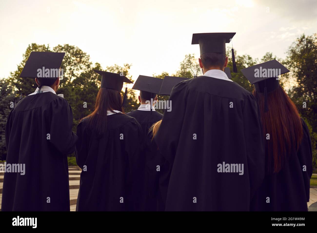 Back view of college or university graduates in black caps and gowns at ...