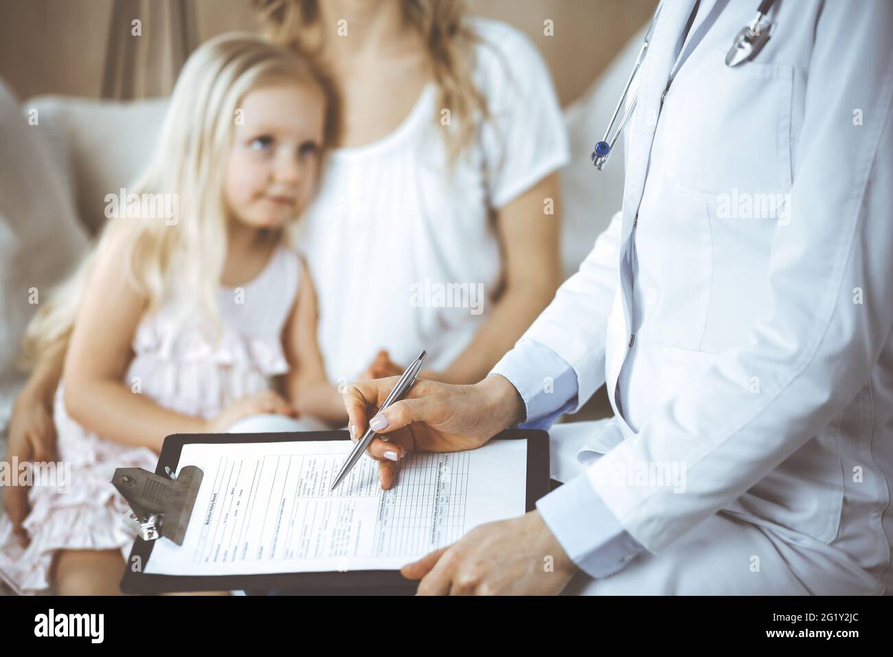 Doctor and patient. Pediatrician using clipboard while examining little ...