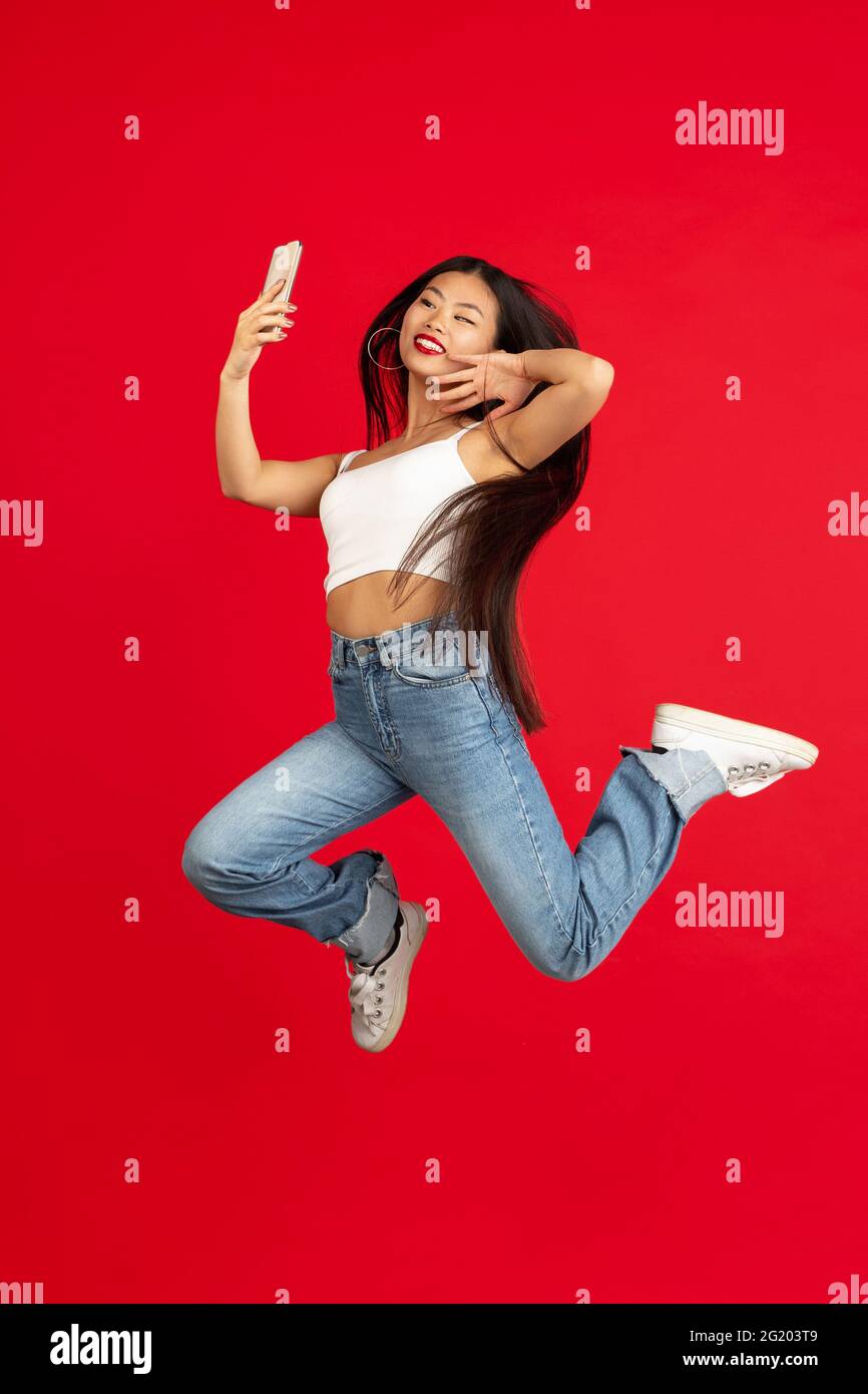 always on mobile. Full length of pretty young woman taking phone while ...