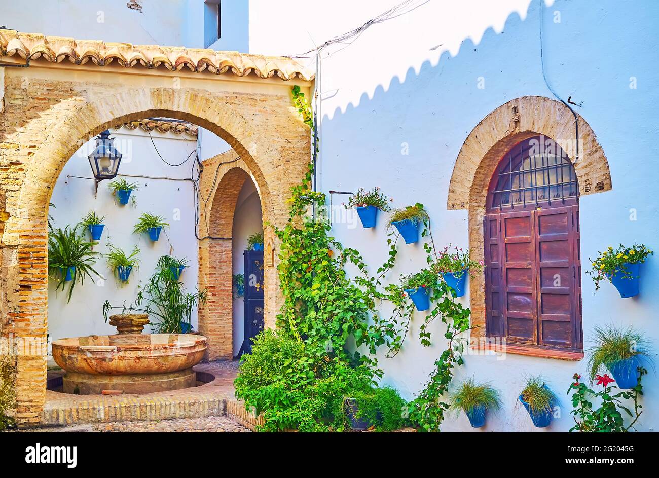 The medieval Cordovan Patio with brick arch, fountain and numerous ...