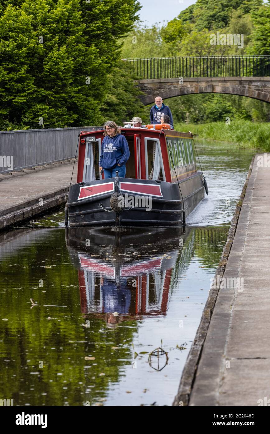 A canal boat passes over a viaduct on the Union Canal near Edinburgh ...