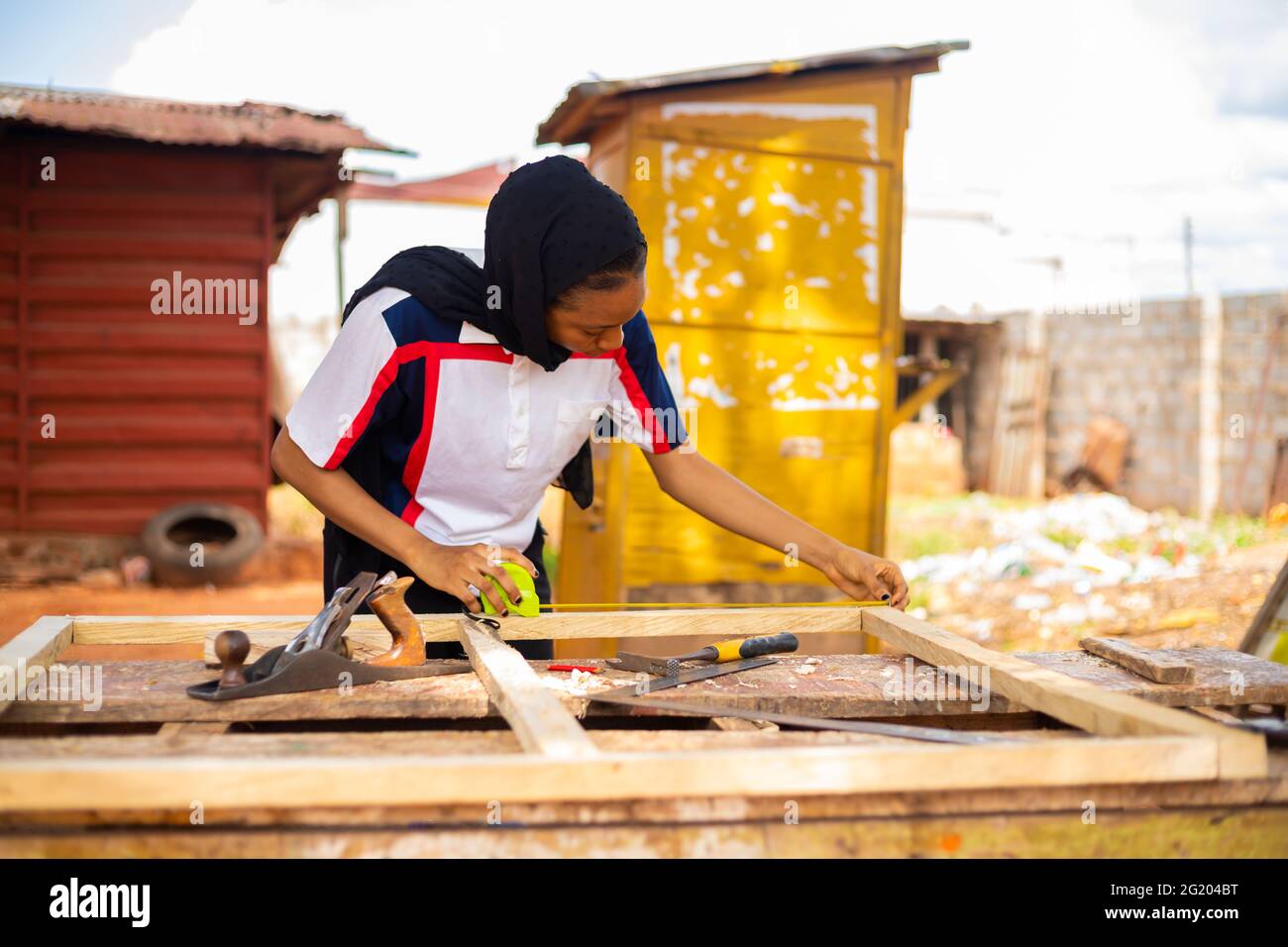 Female African professional carpenter smiling as she takes a ...