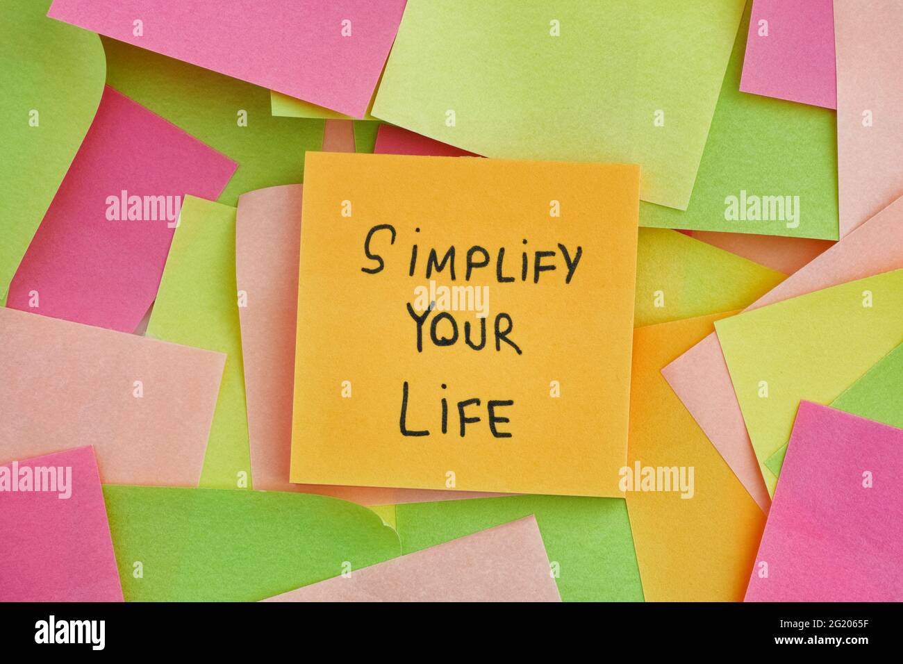 A yellow paper note with the phrase Simplify Your Life written on it ...