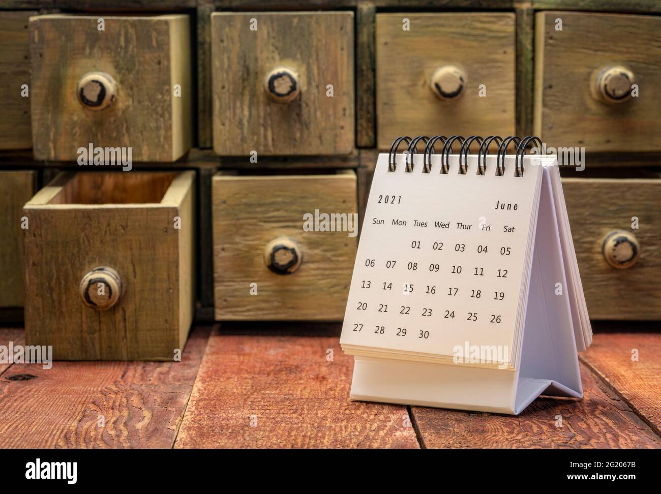 June 2021 - spiral desktop calendar on a weathered barn wood table with ...