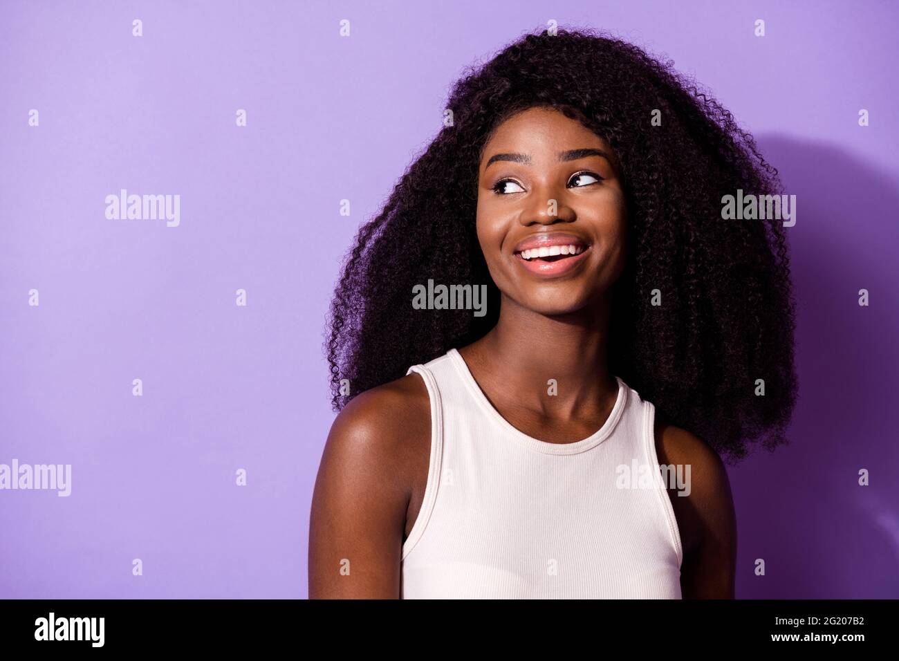 Portrait of attractive cheerful wavy-haired girl looking aside copy ...