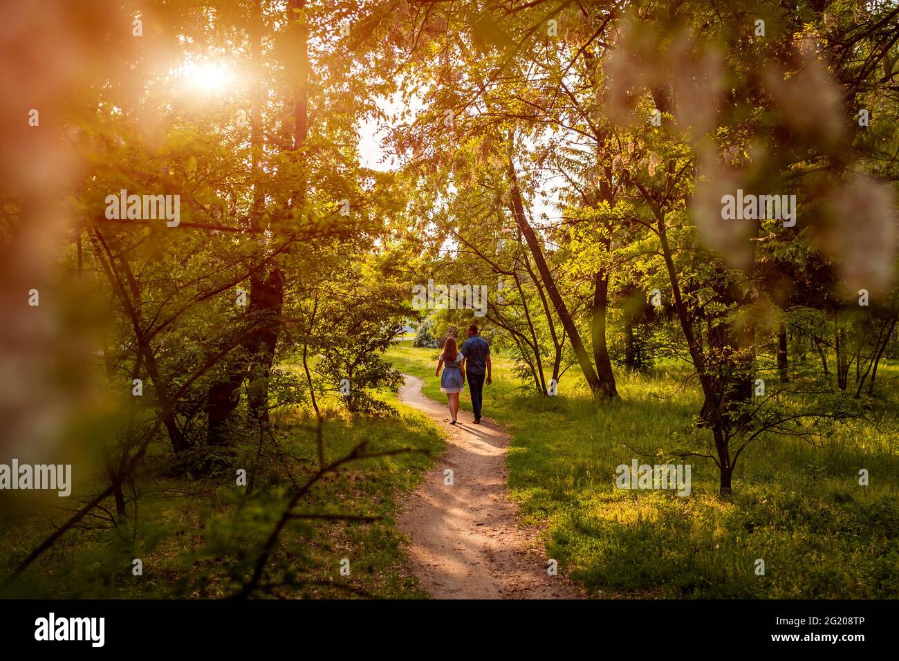 Happy couple having fun in spring field. Young man and girl hugging and ...