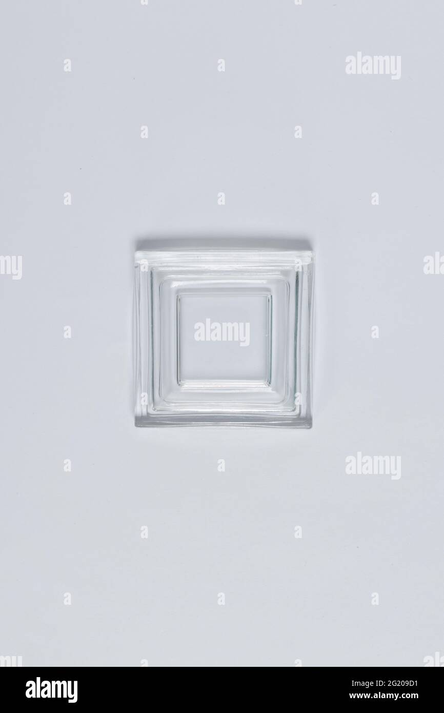 Vertical shot of a square transparent glass object on a white ...