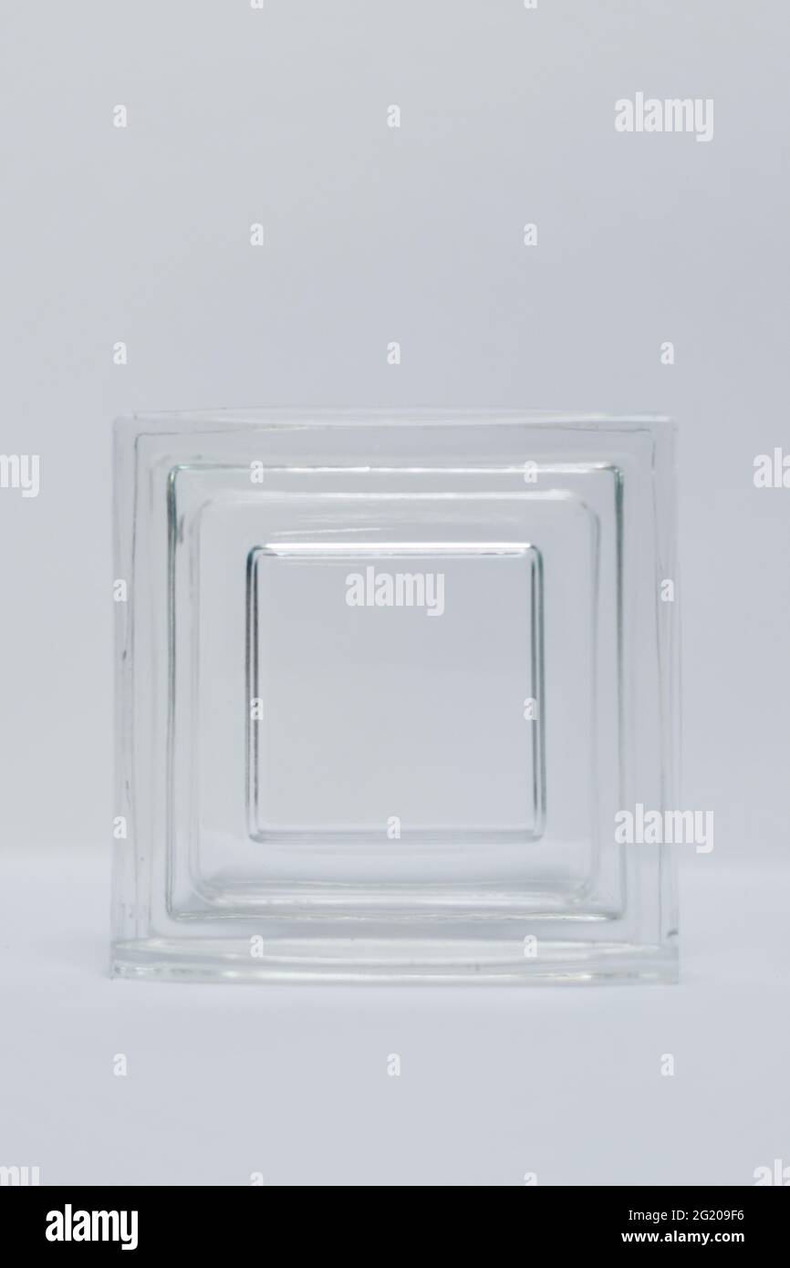 Vertical shot of a square transparent glass object on a white ...