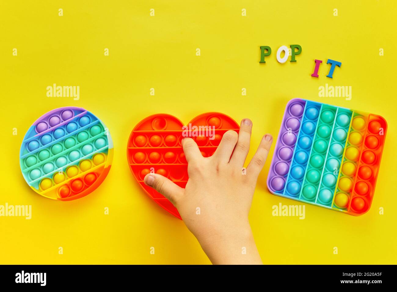 Kid hands playing with colorful pop It fidget toy. Colorful antistress ...