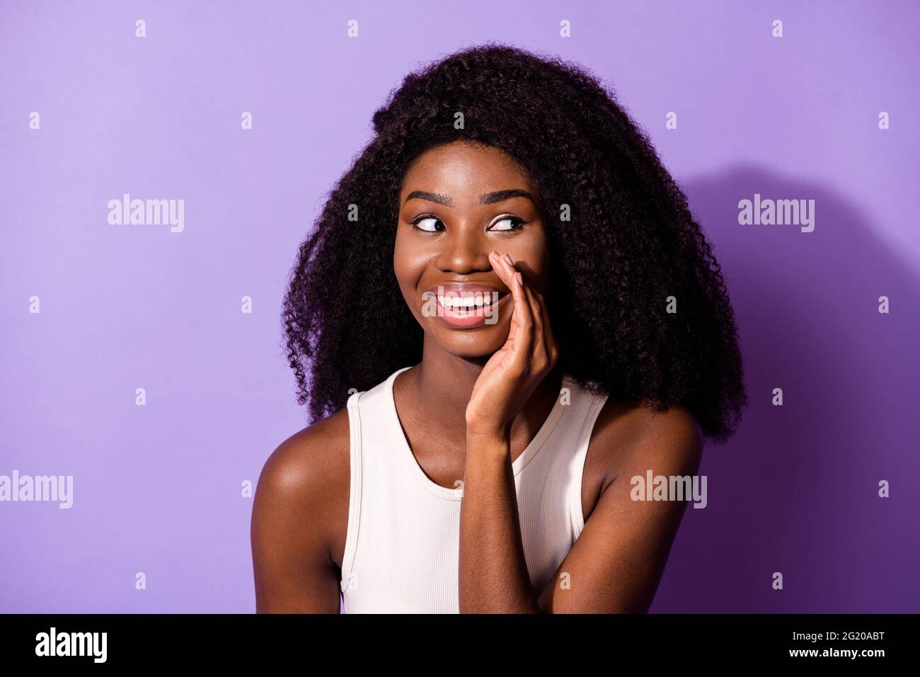 Portrait of charming positive dark skin lady hand near mouth speak look ...