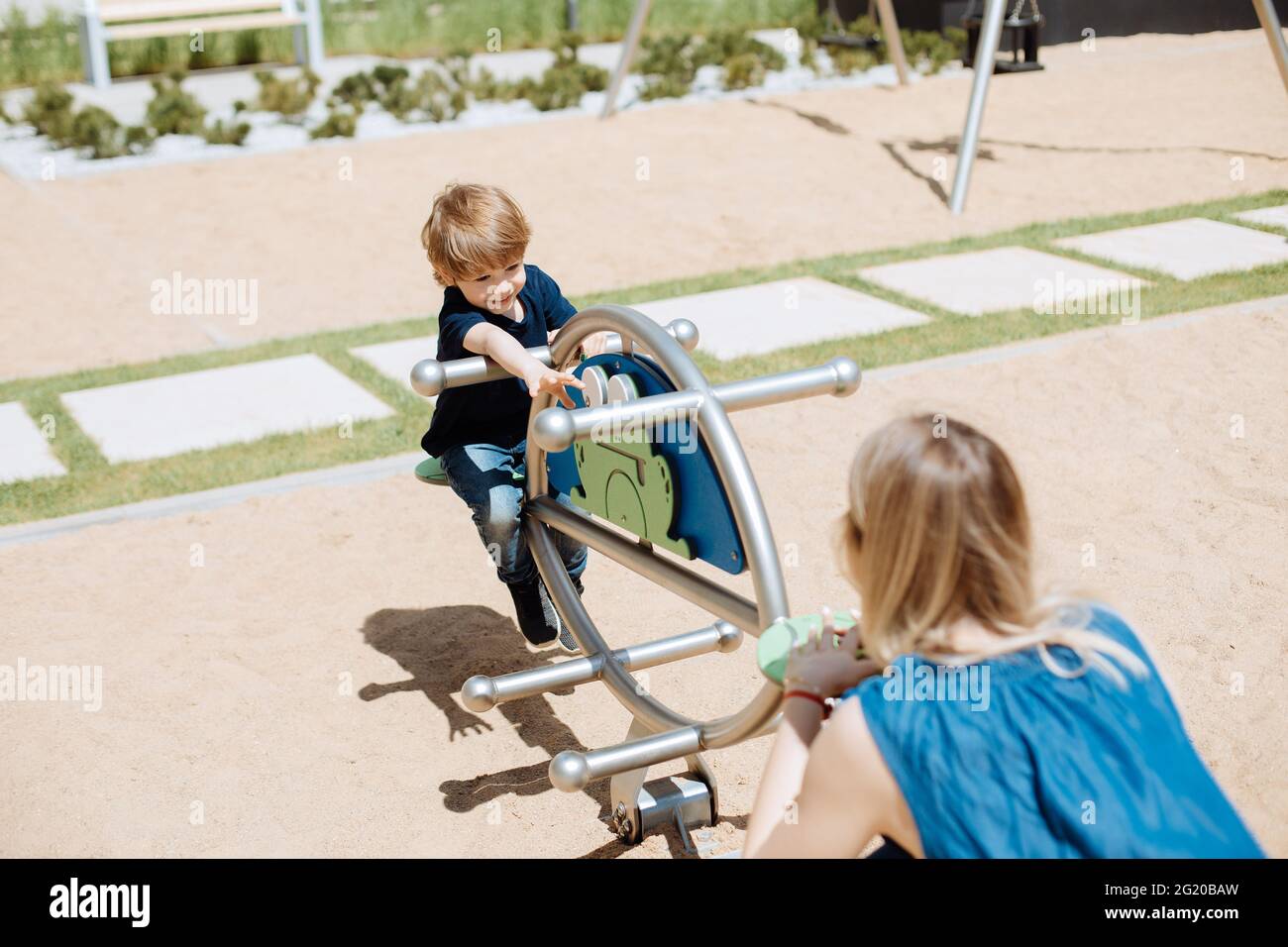Happy child playing on playground with nanny. Outdoor activities for ...