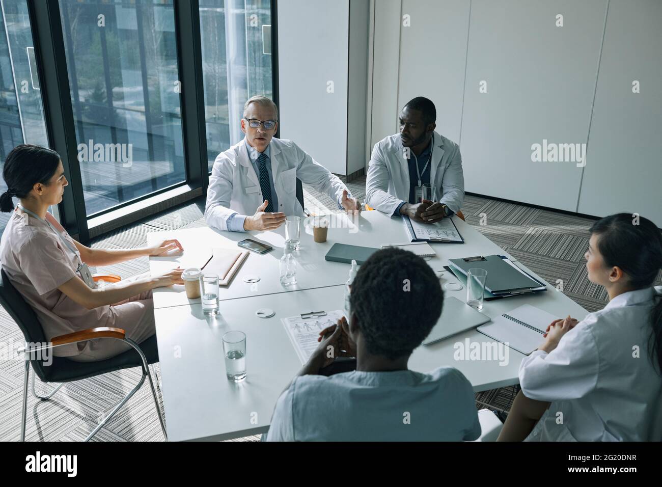 High angle view at group of doctors sitting at meeting table in ...
