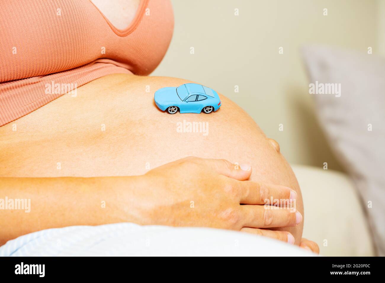 Toy car on big pregnant woman's belly, close-up Stock Photo - Alamy