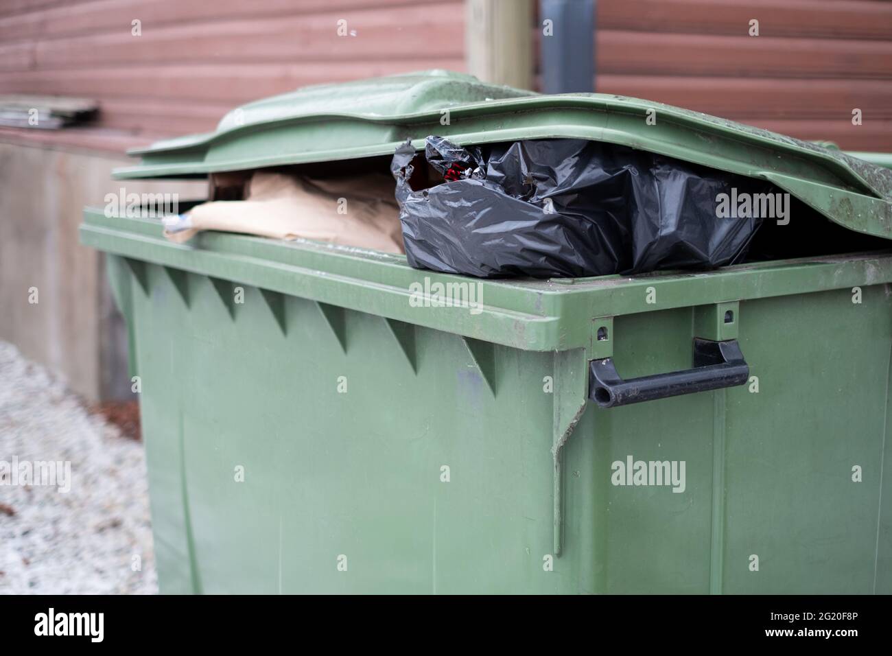 Over filled green garbage bin Stock Photo - Alamy