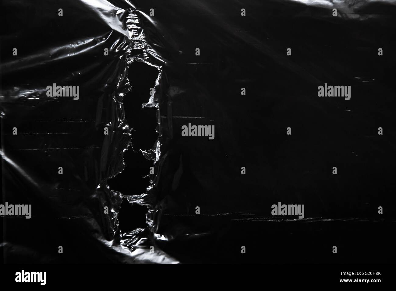 Polyethylene surface with ragged hole on black background Stock Photo ...