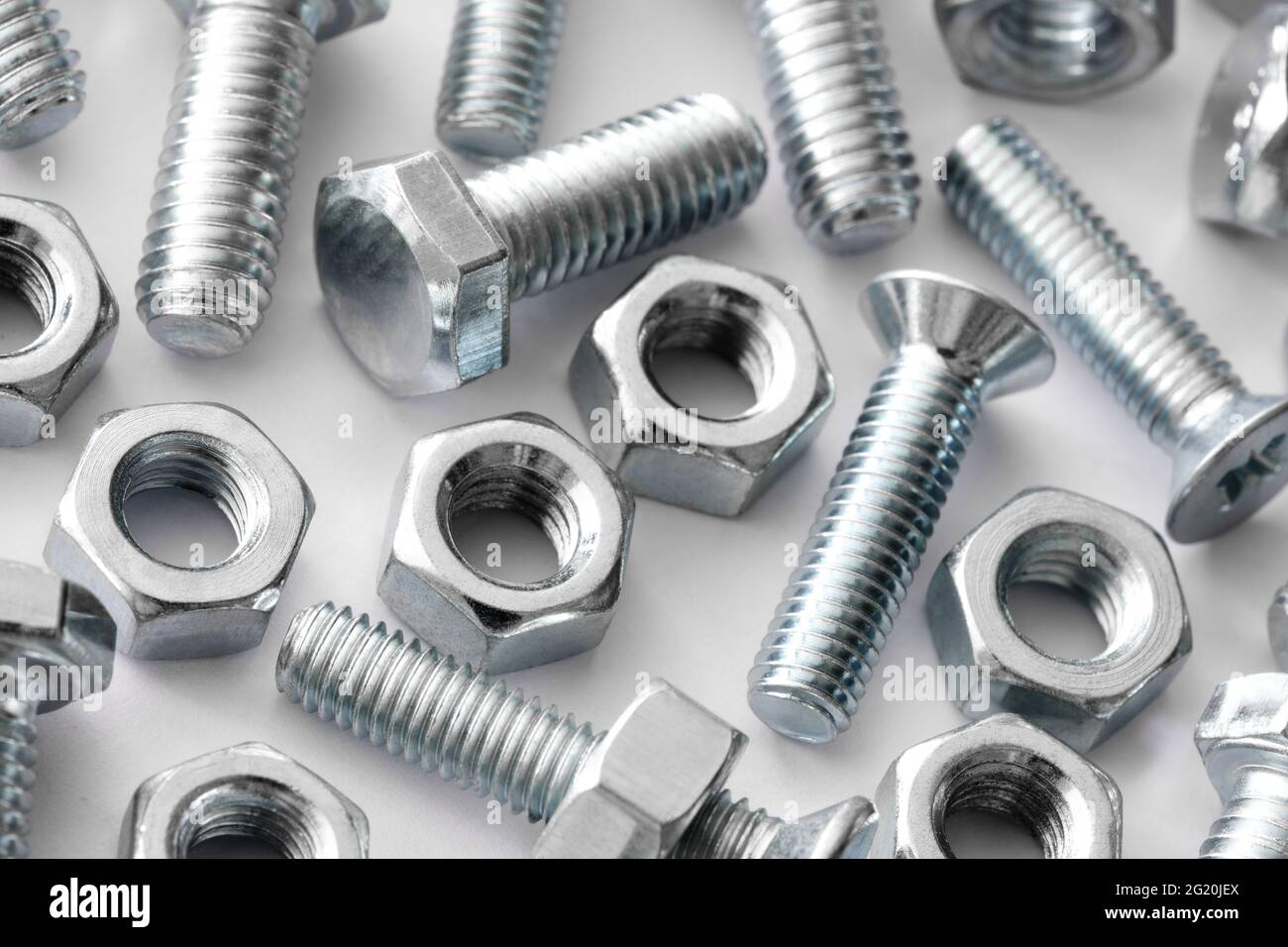 Many metal nuts and bolts on white background Stock Photo - Alamy