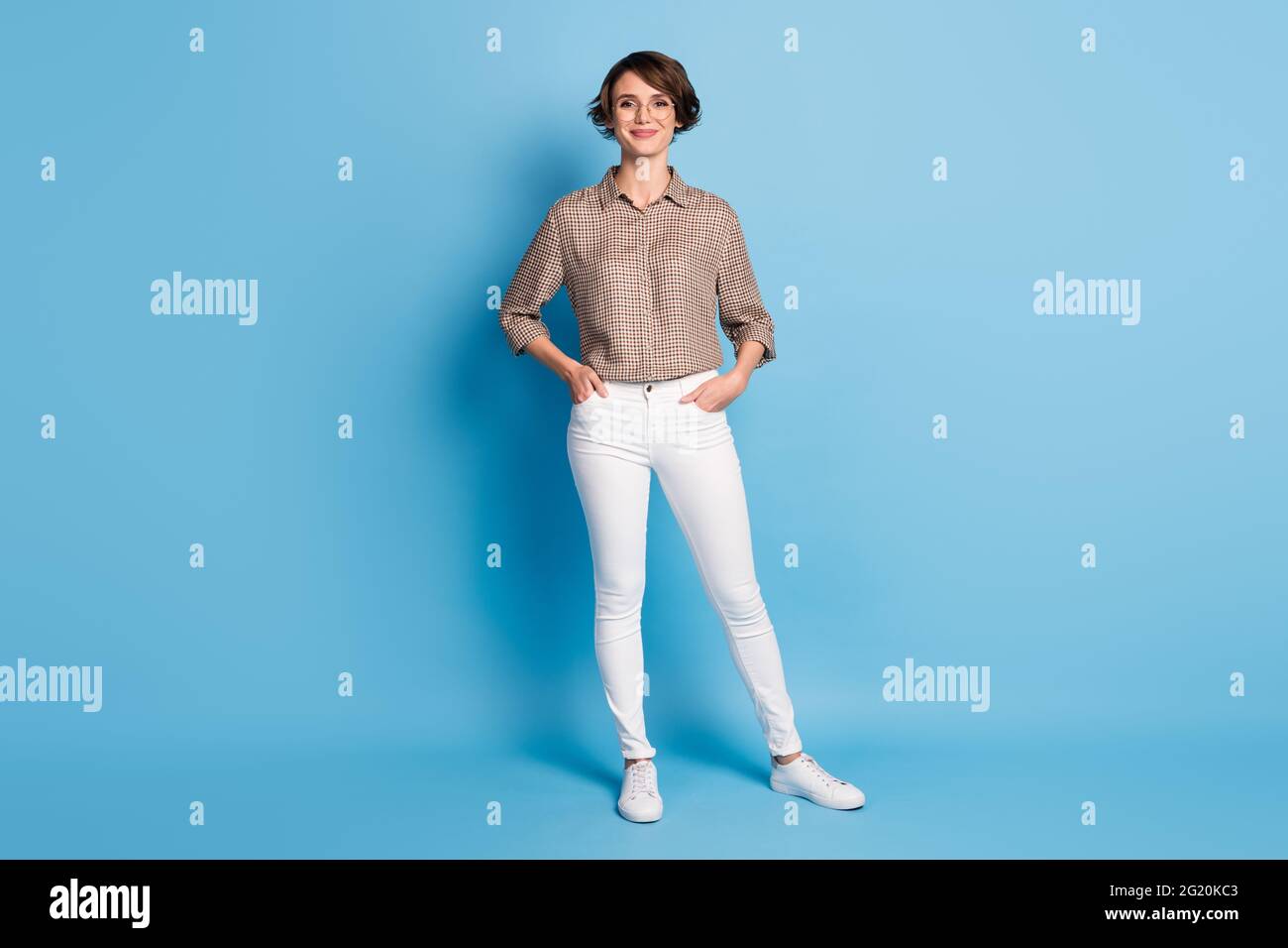 Full body portrait of attractive satisfied person out arms in pockets ...