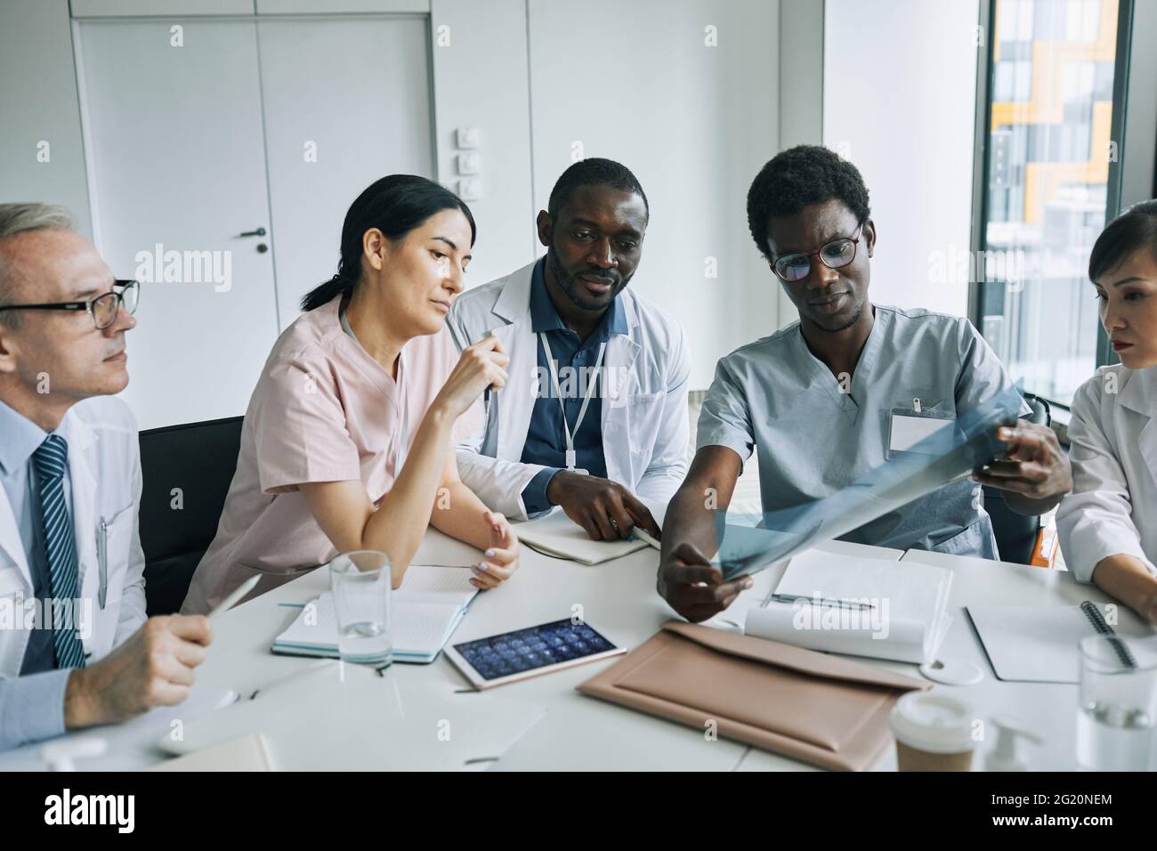 Diverse group of medical professionals working together at meeting ...