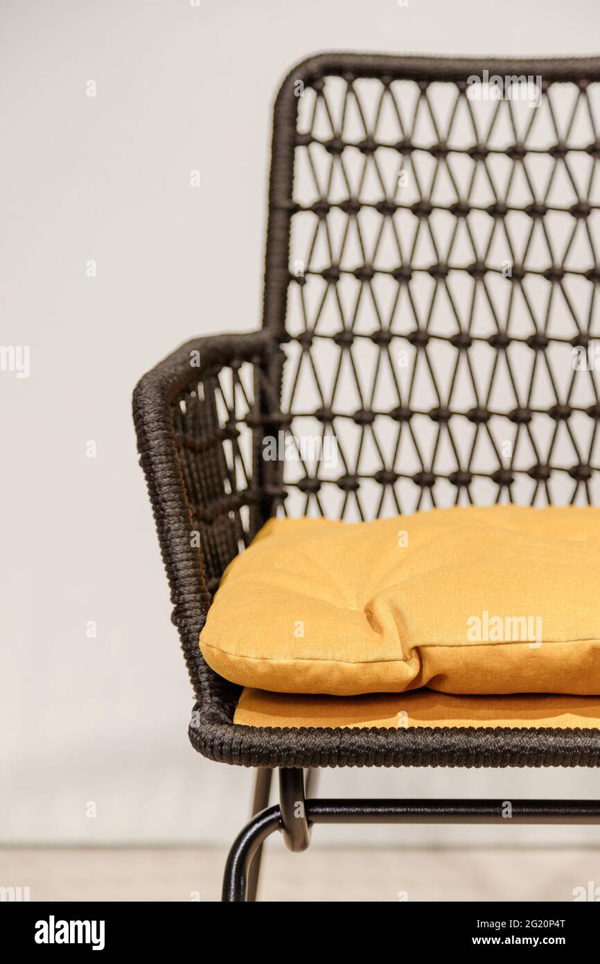 Black wicker chair with yellow pillows. Details Stock Photo - Alamy