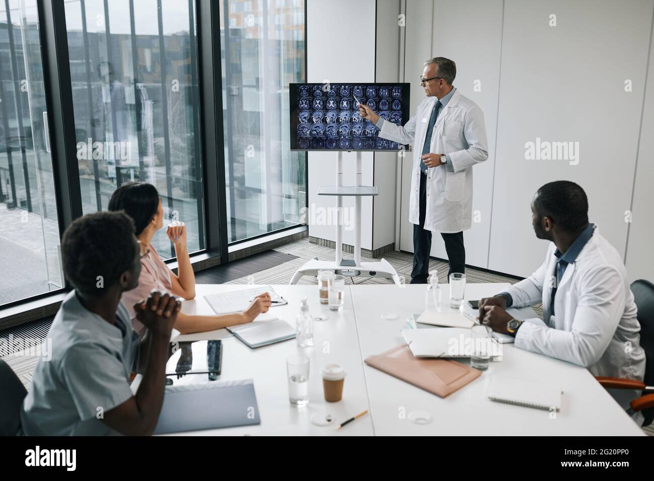 Wide angle portrait of mature doctor giving presentation at medical ...