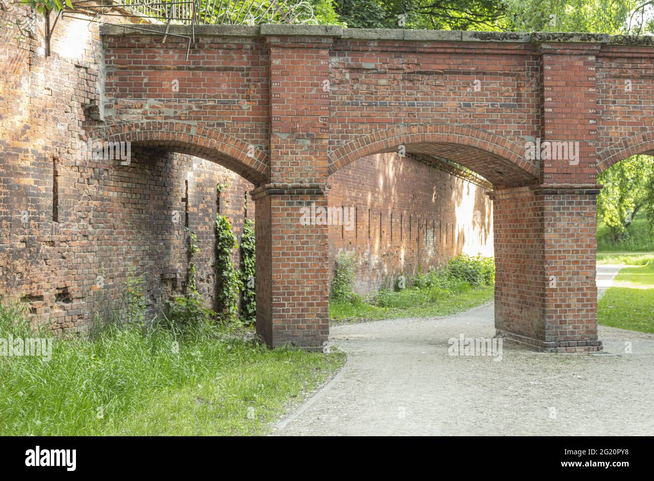 An arched red stone bridge in an old castle. View of the bridge with an ...