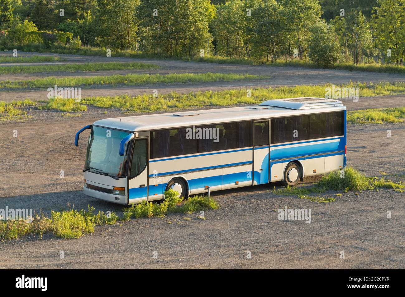 The bus stands in a field on a dirt road. Bus in the middle of the ...