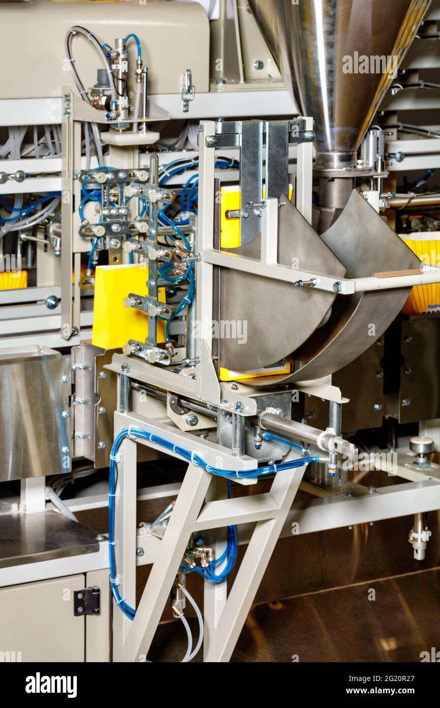 A fragment of a production line for packing bulk products into yellow ...