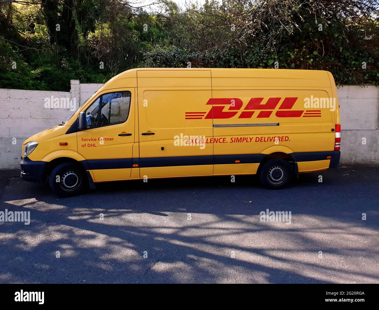 BRAY, IRELAND - Apr 17, 2021: Side view of DHL yellow van parked in the ...