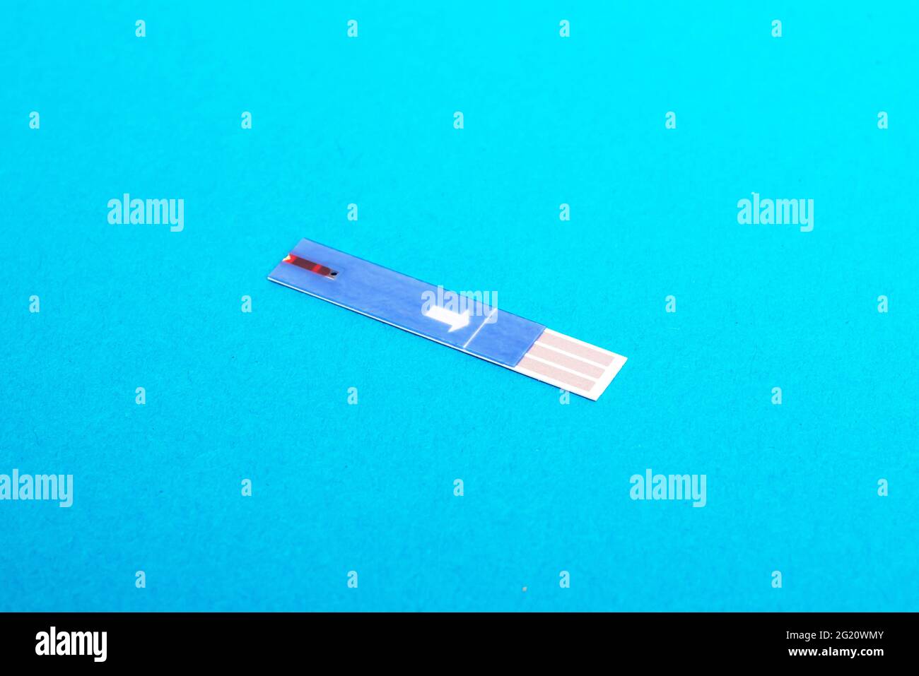 Used blood glucose meter test strip on a blue background Stock Photo ...