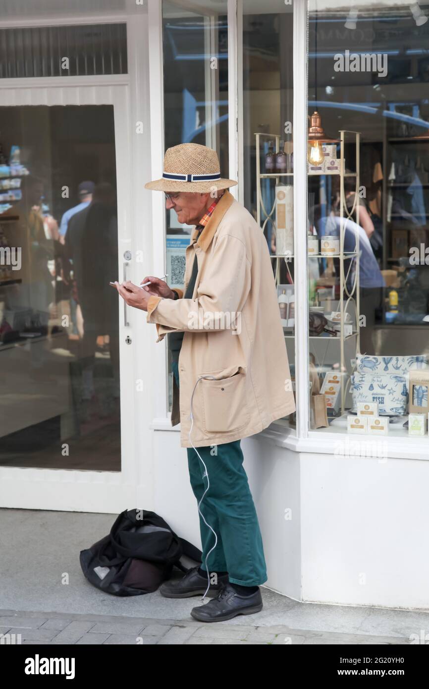 A street painter artist painting on Fore Street, St. Ives, Cornwall, UK ...