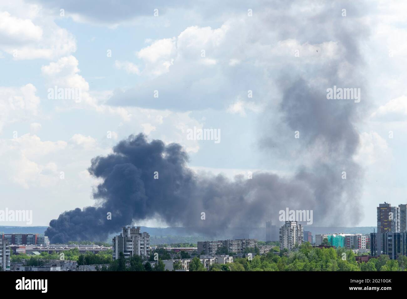Fire in the city. Black column of smoke rises to the sky over city ...