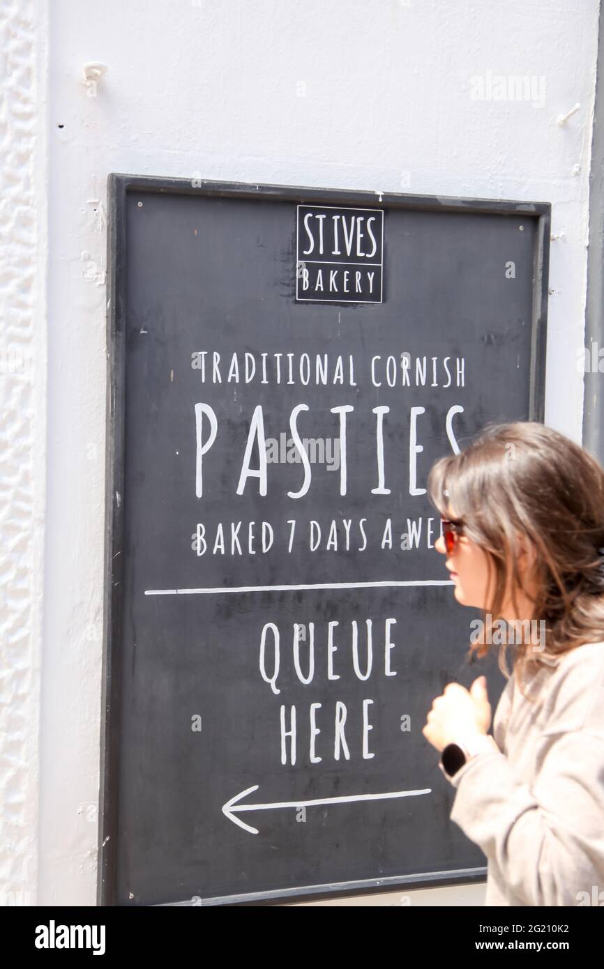 A woman outside St. Ives Bakery, Cornish bakery, Fore Street, St. Ives ...