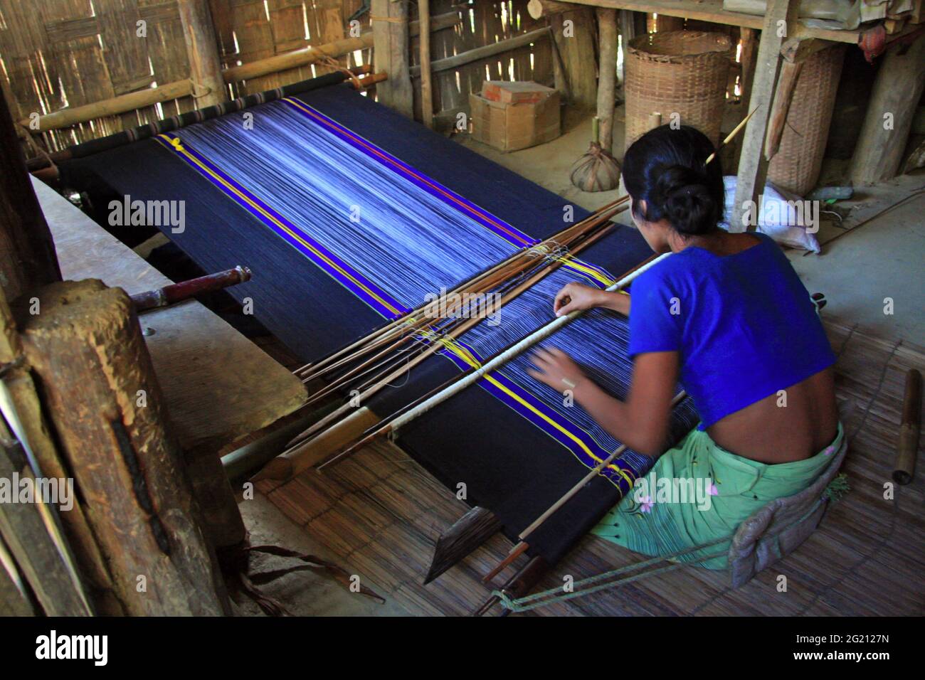 An ethnic woman weaving clothes with a handloom in Thanchi in Bandarban ...