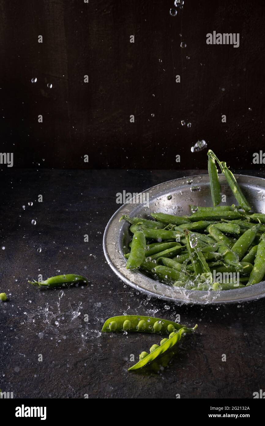 pea pods on a brown background with spray and splash of water Stock ...